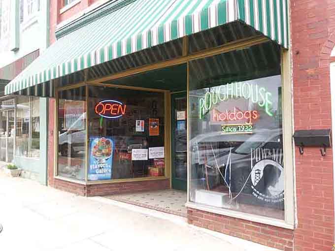 A neon "Roughhouse Hotdogs Since 1932" sign glowing in the storefront window is basically a masterclass in understated, delicious confidence.
