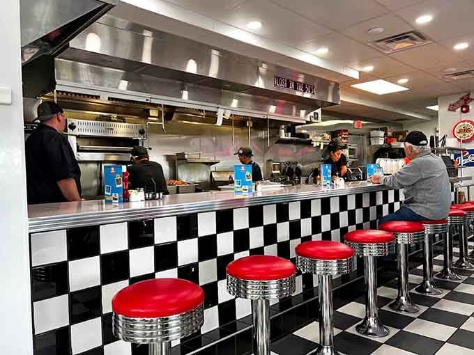 Red stools, checkered tiles, and a kitchen humming with purpose. This counter has seen some seriously good meals.