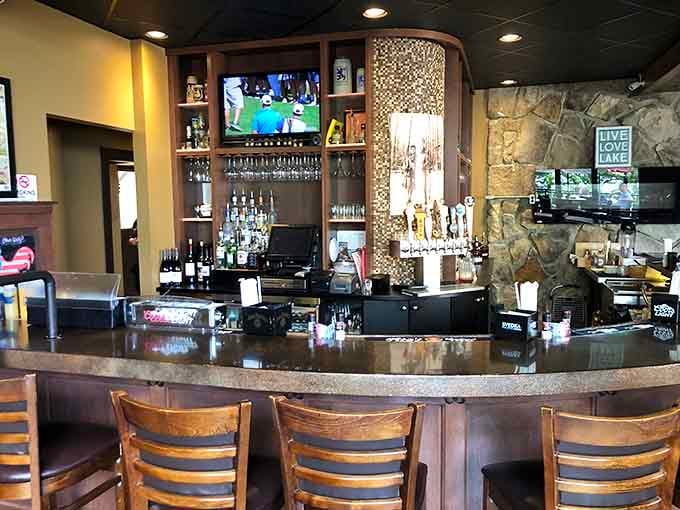 The bar beckons with craft beers and lake views, proving that sometimes the best seat isn't at the table.