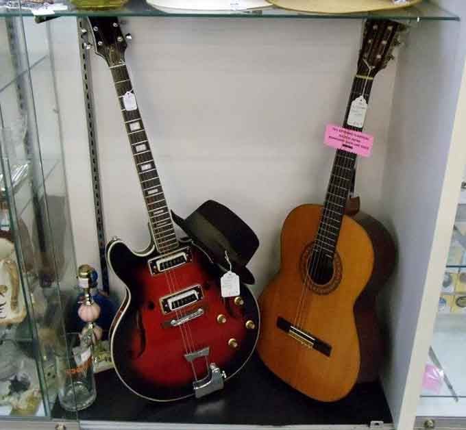 Two vintage guitars leaning together like old friends, waiting for someone to give them a second act.