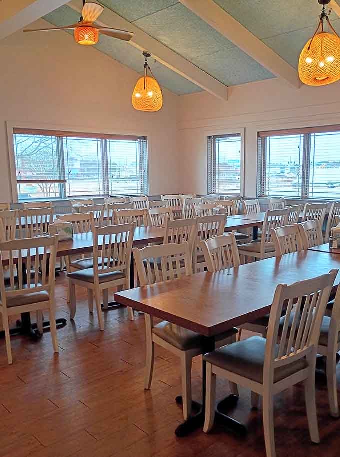 Wicker pendant lights, vaulted ceilings, and rows of white chairs. This dining room means business in the best possible way.