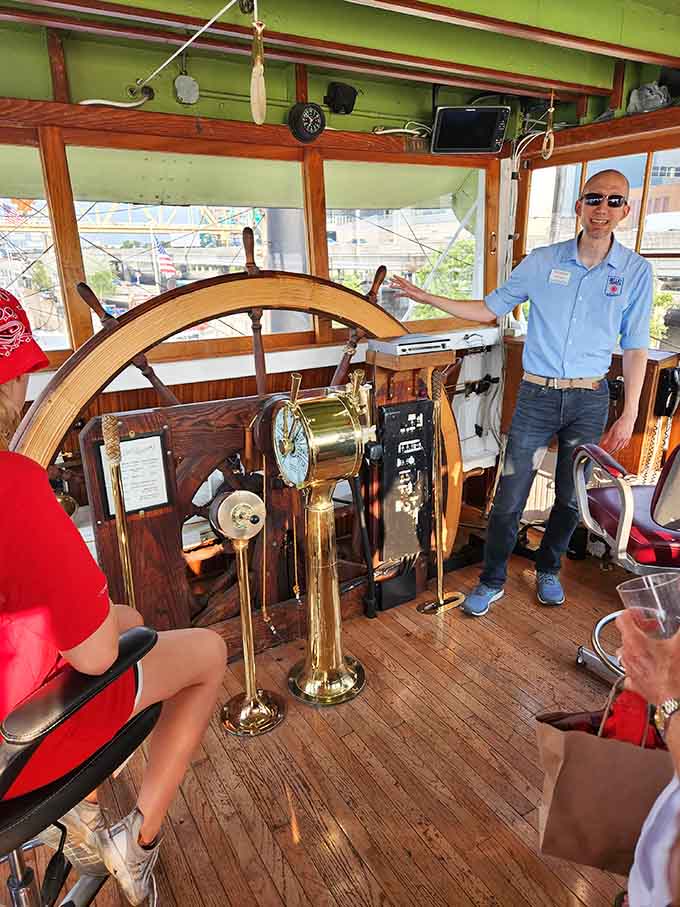 A big wooden wheel, polished brass fittings, and a crew member who clearly loves every word of this story.