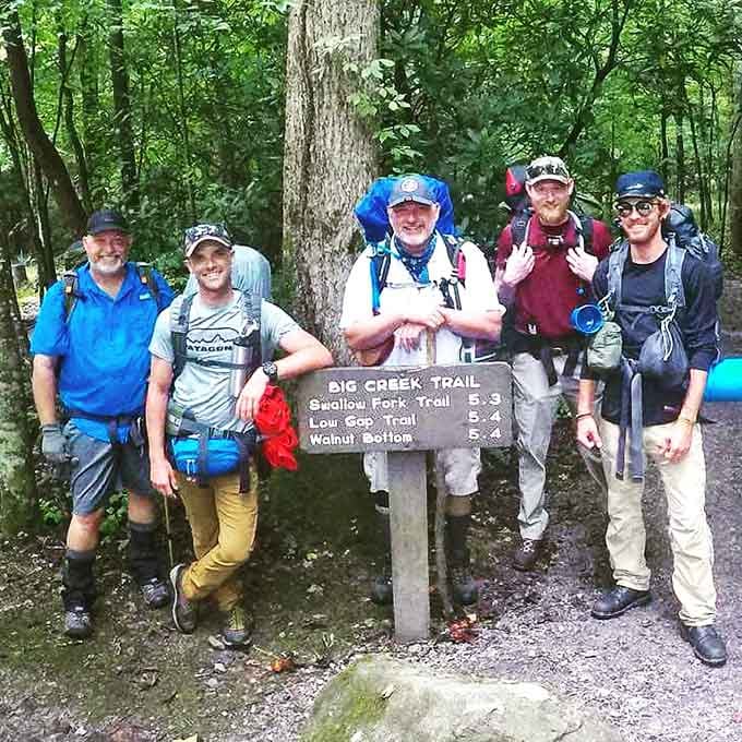 Full packs, big smiles, and a trail sign pointing toward adventures that no algorithm can recommend.