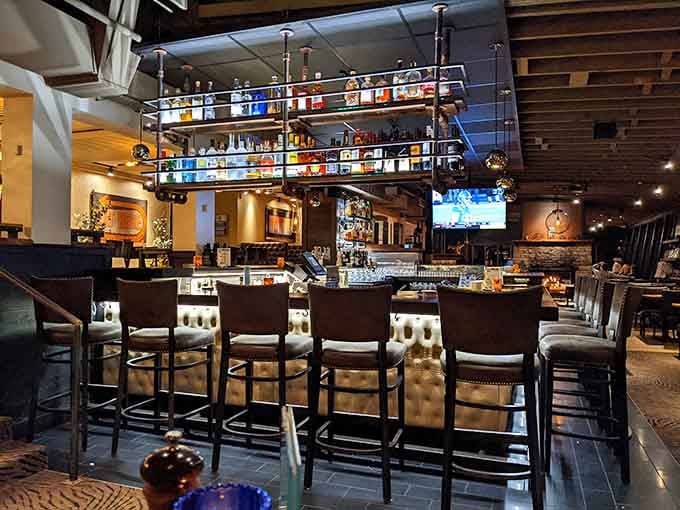 The well-stocked bar features colorful bottles displayed overhead, ready to craft your next favorite drink.