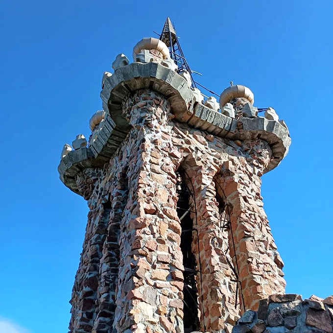 Turrets topped with ornate stonework reach toward Colorado skies, each detail placed by hand over decades of dedicated construction work.