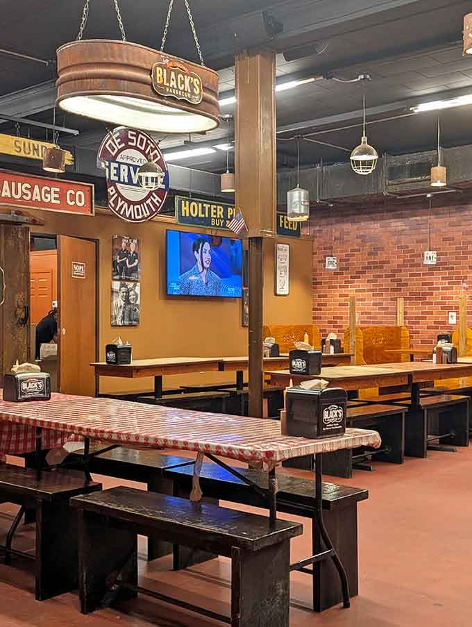 Vintage signs covering every wall, a flat screen showing the game, and long wooden tables ready for serious eating, perfect setup.