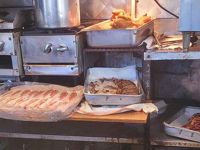 Trays of meat prepped and ready, a well-worn stove humming along. This kitchen has a rhythm, and it has clearly never missed a beat.