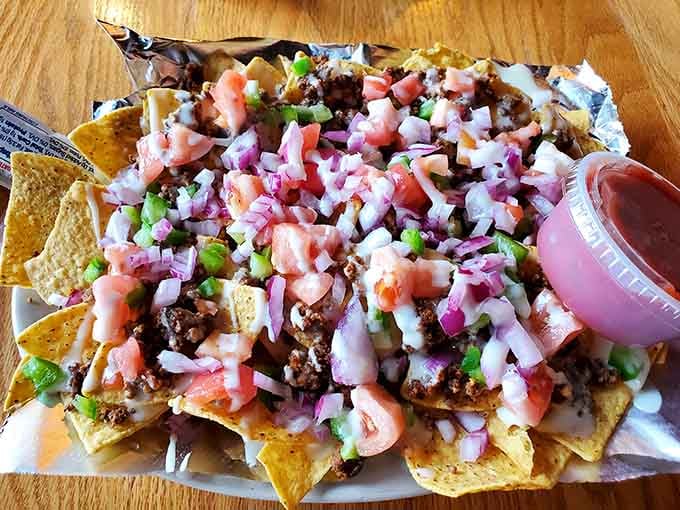Loaded nachos piled high with beef, tomatoes, onions, peppers, and cheese. This is not a snack, it's a commitment.