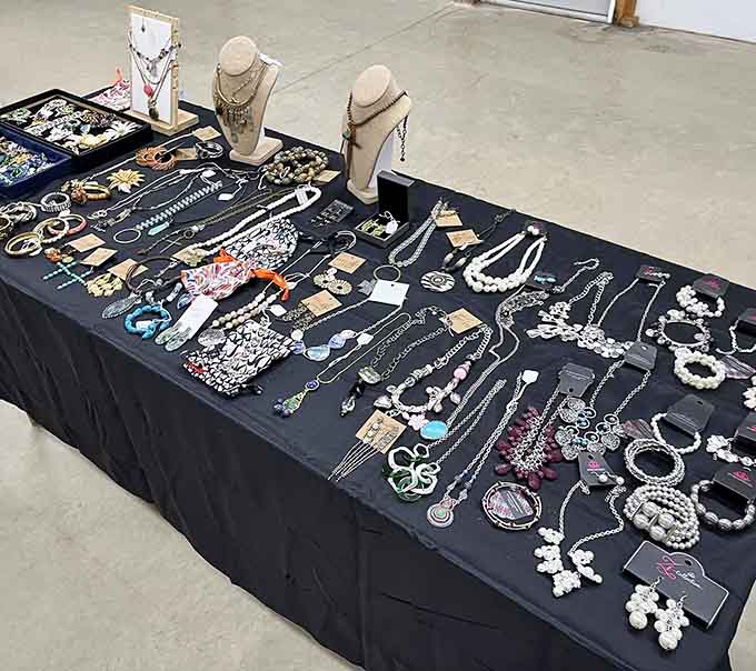 A full table draped in black and covered in necklaces, bracelets, and earrings, like a jewelry store decided to throw a very elegant party.