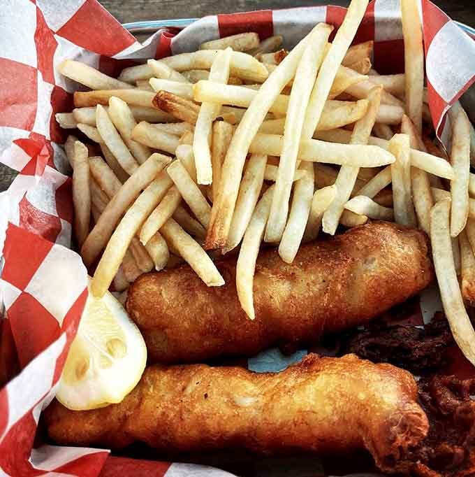 Golden battered fish, a mountain of crispy fries, and a wedge of lemon. Classic fish and chips done with the confidence of a seasoned kitchen.