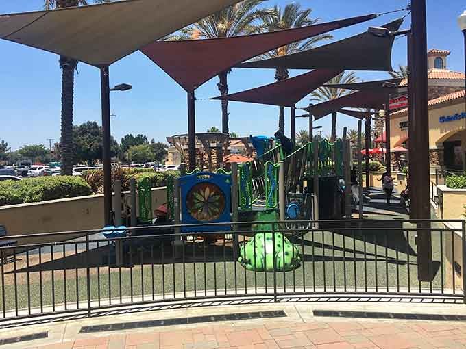 A fenced playground with shade sails overhead means the little ones stay cool while you keep browsing guilt-free.