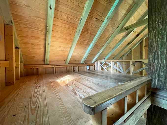 That sloped ceiling and raw wood create the kind of cozy sleeping loft that makes going to bed feel like an adventure.