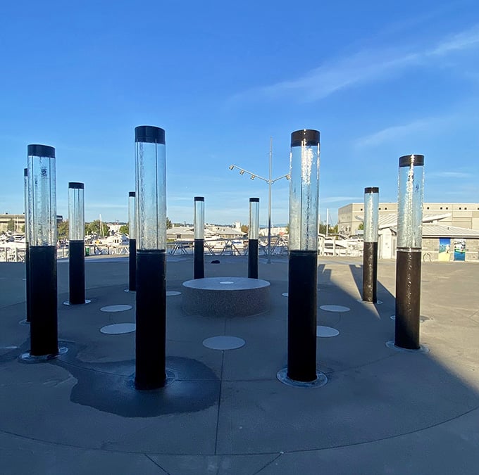 Glass cylinders catching light against a blue sky, proof that outdoor art installations can genuinely stop you mid-stride.