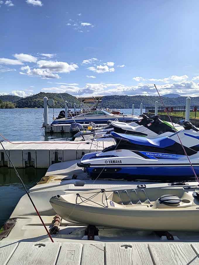 Jet skis, kayaks, and fishing rods all sharing the same dock. Democracy in action, lakeside edition.