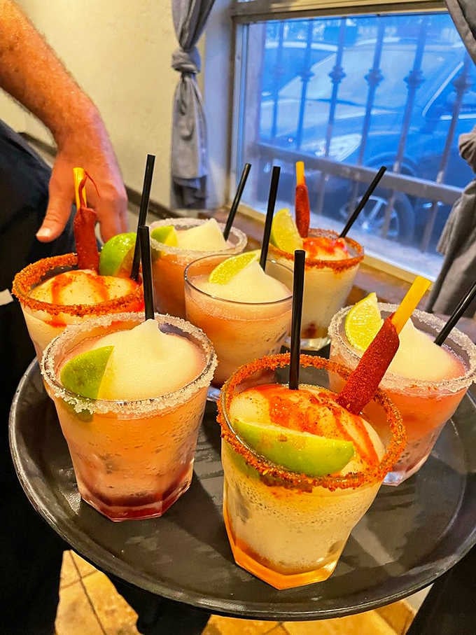 A full tray of spicy, chili-rimmed margaritas heading somewhere very lucky — follow that server immediately.