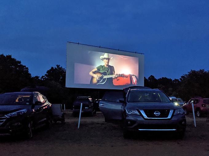 A guitar-strumming cowboy filling that massive screen while the deep blue sky does its thing behind him.