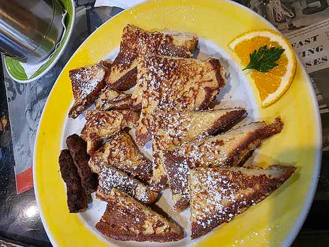 French toast dusted with powdered sugar and served with a fresh orange slice. Simple, golden, and exactly what a good morning looks like.