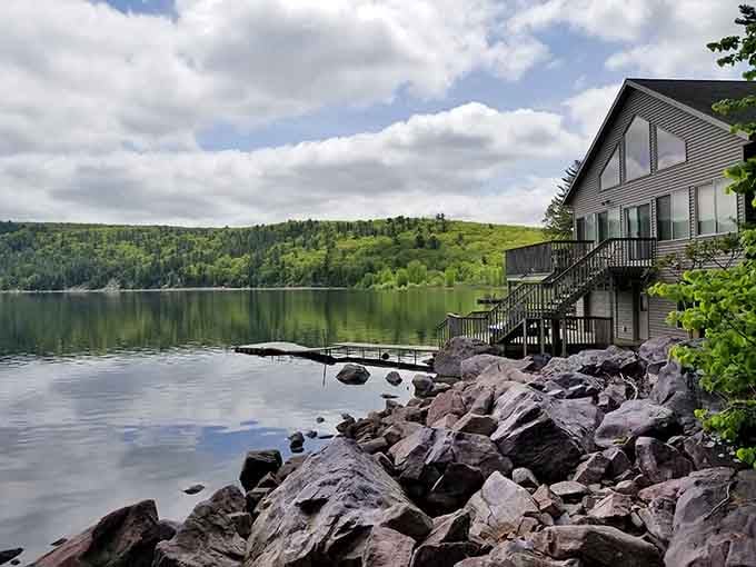 Rocky shoreline, glassy water, and a reflection so perfect it looks like the lake is trying to outdo the scenery above it.