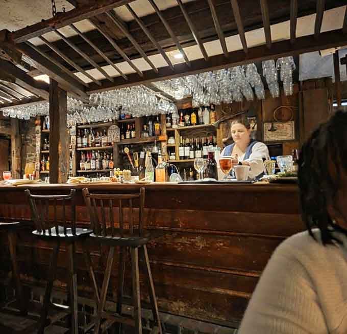 Glasses hanging overhead, bottles lined up behind the bar, and a bartender who looks right at home in another century entirely.