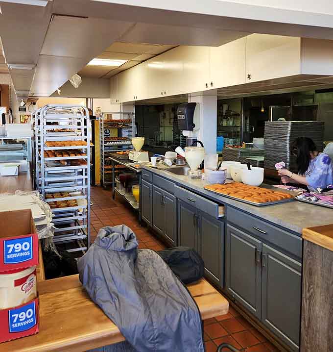 Behind the counter at Dom Bakeries, the real magic happens. Racks full of fresh donuts say everything.