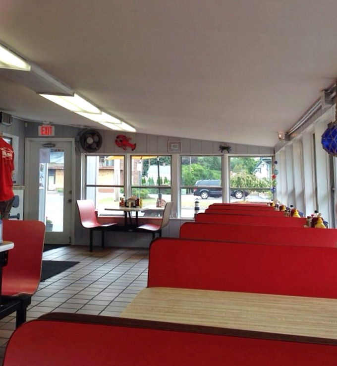 Long rows of red booths bathed in natural light. Simple, comfortable, and completely inviting.