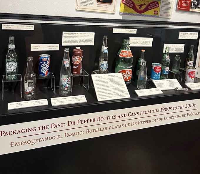 From 1960s glass bottles to modern cans, this display is basically a time machine disguised as a soda collection.