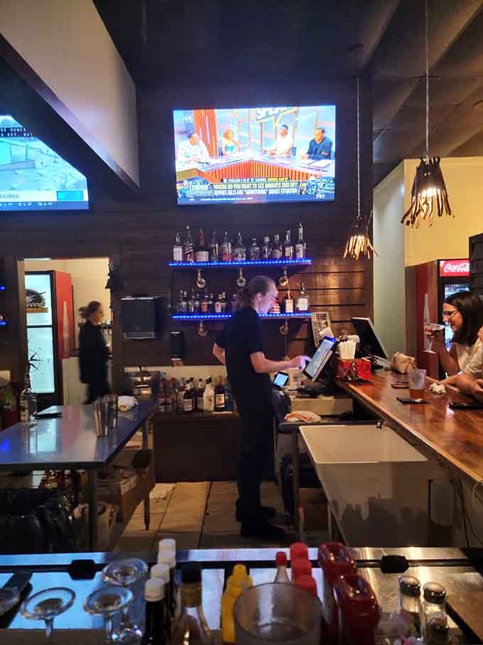 The bar area where friendly faces mix drinks and probably know half the customers by name.