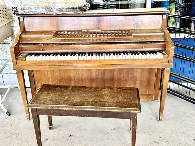 A classic upright piano with its bench, sitting patiently and waiting for someone to give it a second act at home.