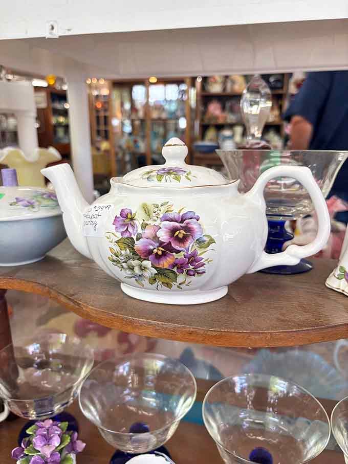A floral porcelain teapot painted with purple pansies, the kind of piece that makes afternoon tea feel genuinely civilized.