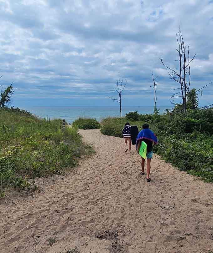 Two people heading toward the water with towels in hand, making the smartest decision of their entire week.