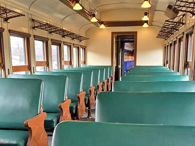 Green seats, warm wood trim, and small overhead lights. These vintage coaches feel like a first-class ticket through time.