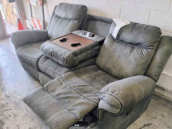 A reclining sofa with a built-in console, because apparently someone donated their entire movie night setup in one go.