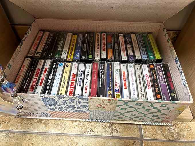 A full box of cassette tapes featuring Barbra Streisand, Julio Iglesias, and Yanni, basically the complete soundtrack of every 1980s dinner party ever thrown.