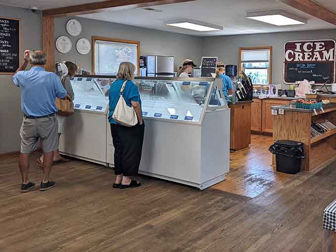 The ice cream display case stretches out like a delicious horizon, and every single person in this room is making a very important decision.