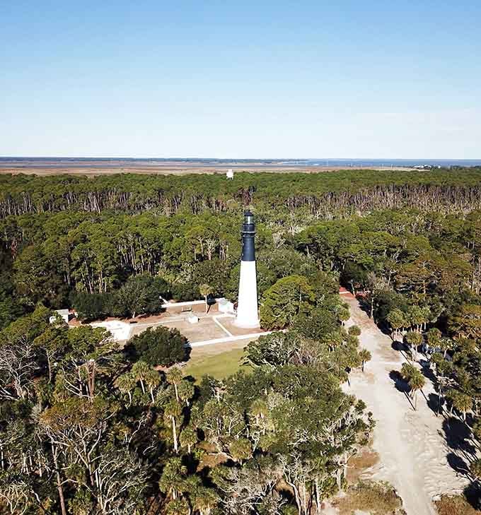 From above, the lighthouse stands like a chess piece placed perfectly in the middle of a green and blue board.