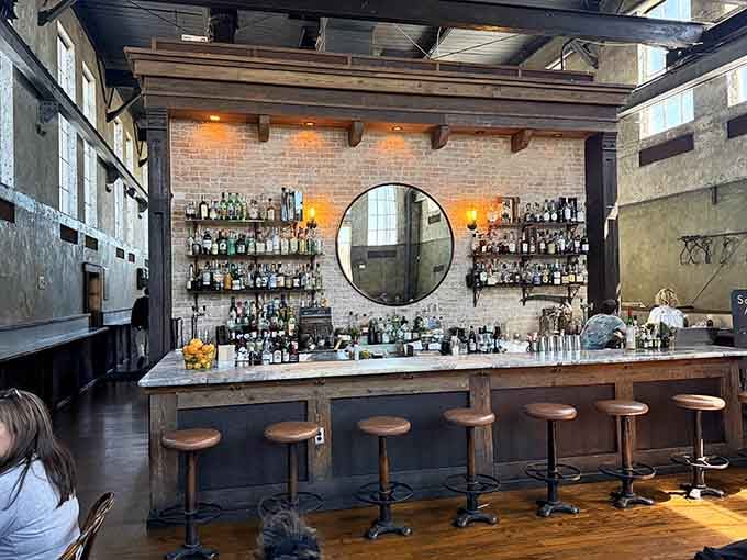 Exposed brick, a round mirror, shelves lined with bottles, this bar looks like it was designed by someone who genuinely loves bars.