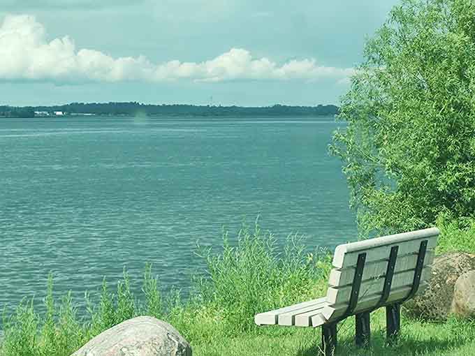 That solitary bench facing the wide, steel-blue river isn't waiting for company. It's waiting for you to sit down and finally exhale.