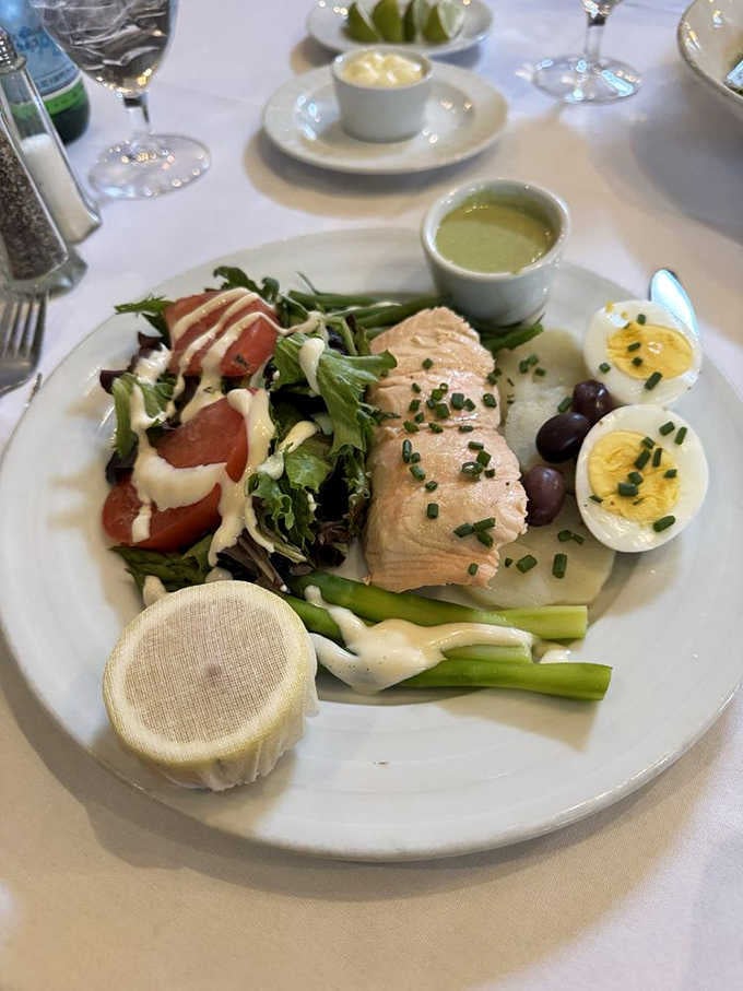 Poached salmon with hard-boiled eggs, olives, and greens. A Ni&ccedil;oise-inspired plate that's as beautiful to look at as it is to eat.