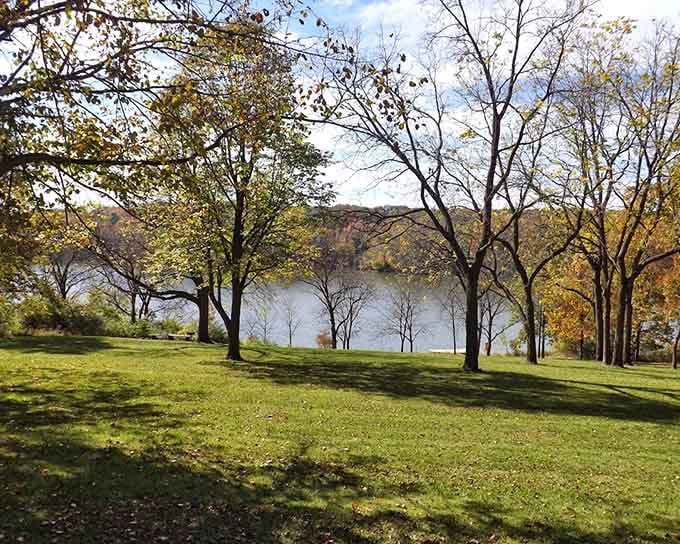 Scattered trees casting long shadows across a grassy slope toward the lake, this is the kind of view that slows your breathing down.