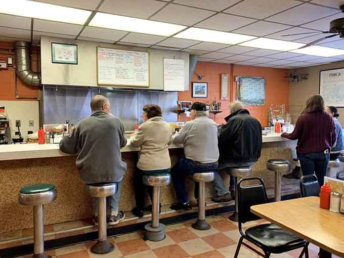 A full counter of regulars leaning in, comfortable and content, the universal sign of a truly great neighborhood diner.