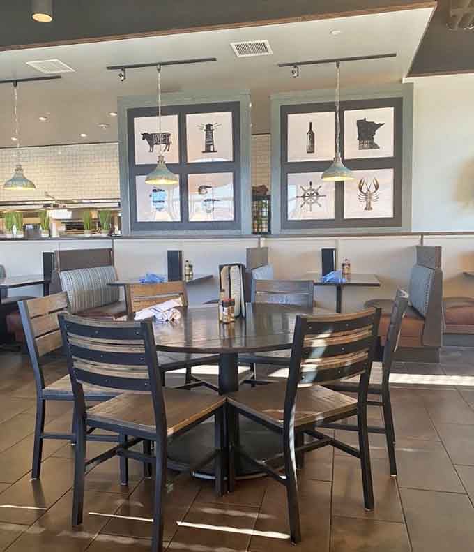 Sunlight streams across round wooden tables beneath framed coastal and Minnesota-themed artwork, a dining room that genuinely invites you to linger.
