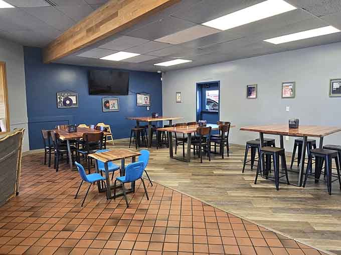 A dining room with deep blue walls, warm wood tables, and vinyl record art. Casual, comfortable, and completely inviting.