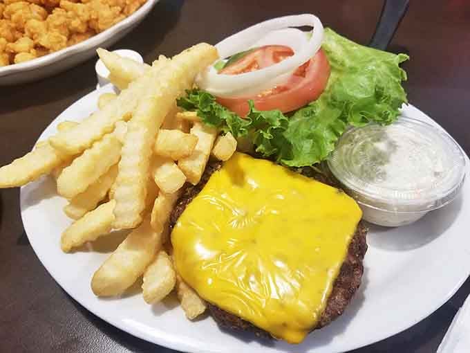 A cheeseburger with crinkle fries proving that Mayflower takes care of absolutely everyone at the table, seafood lover or not.