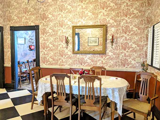 Red and white toile wallpaper, a gilded mirror, and black and white floors, this room has serious personality.