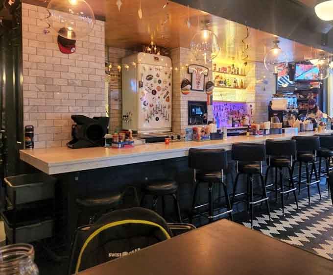 A vintage-style fridge covered in magnets, a glowing bar, and bar stools that are practically begging you to sit down.