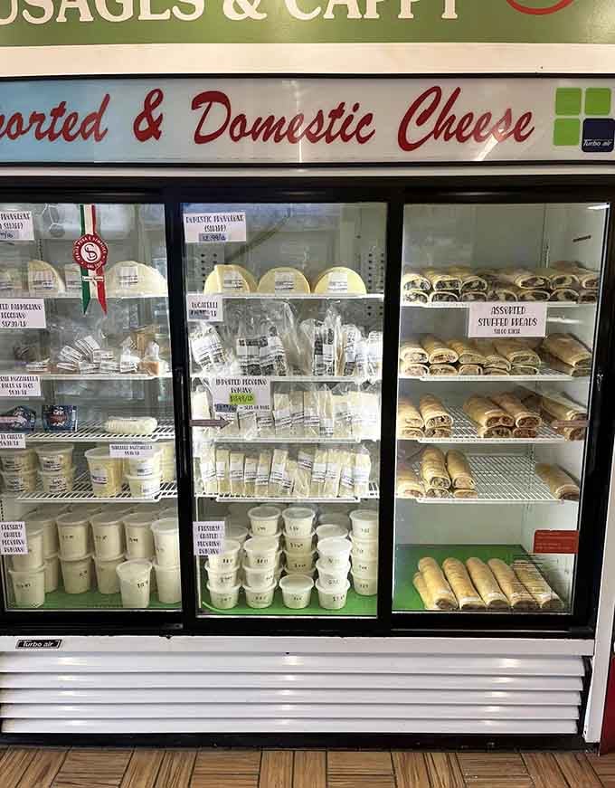 A refrigerator case stocked with imported cheeses, fresh ricotta, and assorted stuffed rolls is basically a dream you can take home.