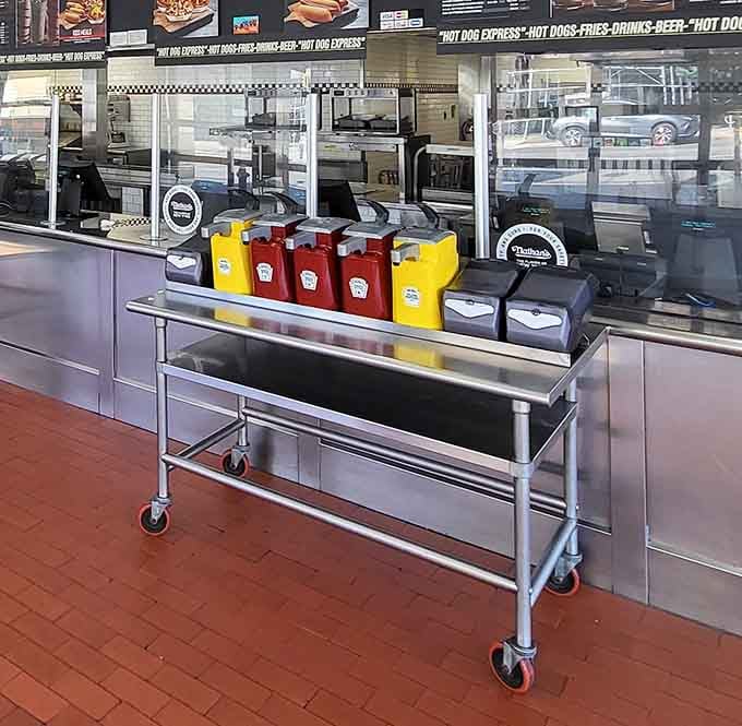Red Heinz, yellow mustard, napkin dispensers lined up like soldiers. The condiment station at Nathan's is ready for whatever you throw at it.