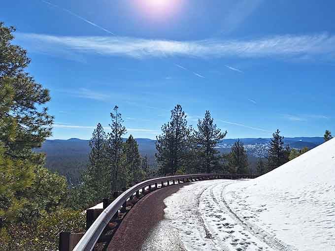 Paulina Lake Road curving through snow on a brilliant blue-sky day, the kind of drive that clears your head completely.