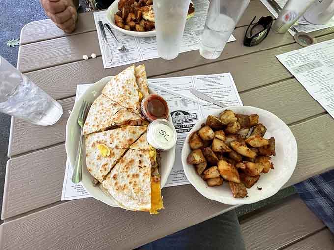 A breakfast quesadilla sliced into wedges and served with a bowl of homefries. Proof that good ideas don't need to be complicated.