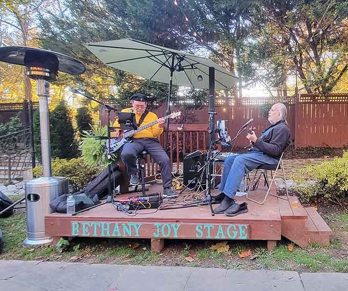 Two musicians playing live on the Bethany Joy Stage outdoors, turning a garden dinner into something you'll genuinely remember.